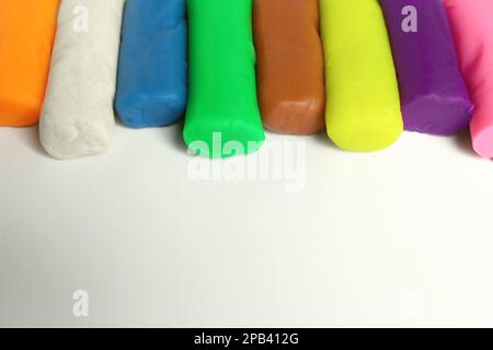 Different color play dough on white background Stock Photo - Alamy