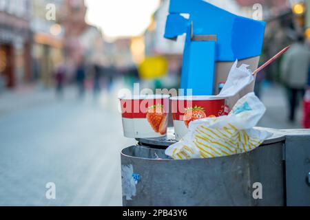 Full wastepaper bin in the pedestrian zone Stock Photo - Alamy