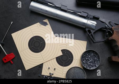 Flat lay composition with sport pistol on black table. Professional gun ...