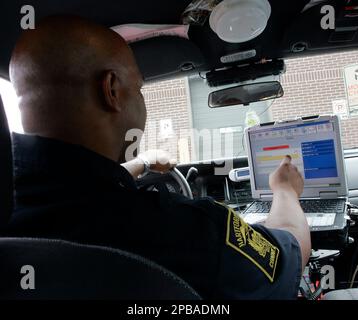 Database, laptop and a police officer in a car for security, urban law ...