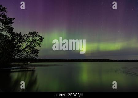 Northern Lights erupt over a Minnesota lake on Oct 7 2024 in the dark ...