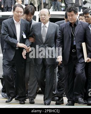 Hanwha Group Chairman and CEO Kim Seung-youn, center, gets out from a police vehicle as he ...