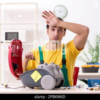 The man repairman repairing vacuum cleaner Stock Photo - Alamy