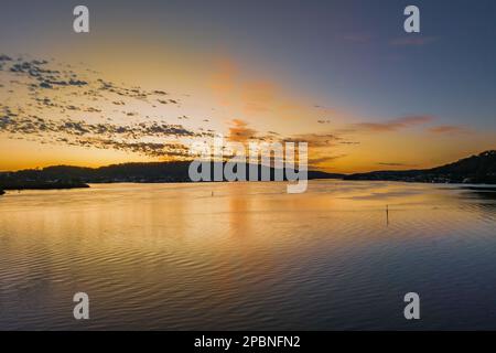 Aerial sunrise over the bay with altocumulus clouds painting the sky at ...