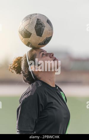 PORTRAIT OF A WOMAN PLAYER BALANCING FOOTBALL ON HEAD Stock Photo - Alamy