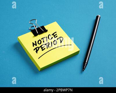 Notice period text on sticky note with hand on blue cover background ...