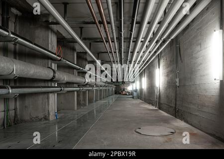 Ceiling mounted industrial pipelines inside underground building, Long ...
