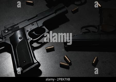 Different guns and bullets on grey table Stock Photo - Alamy