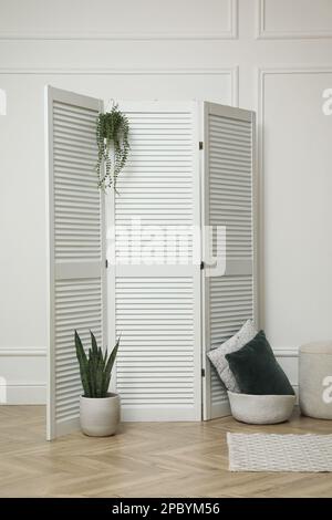 Stylish room with folding screen and floral decor. Interior design ...