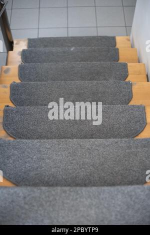 A top view of a staircase with wooden handrails and steps in a modern ...