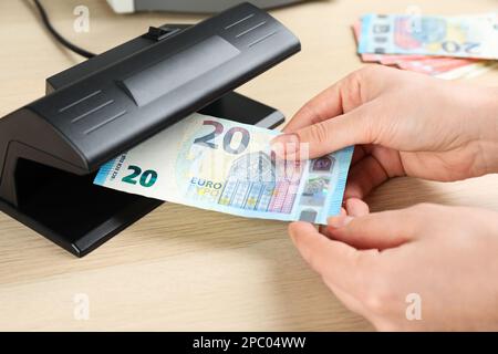 Modern currency detector with Euro banknote isolated on white. Money ...