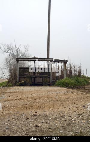 Dry irrigation channel and a rusty weir on a foggy day in the italian ...