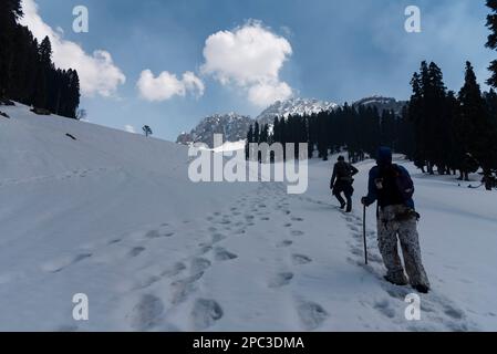 Trekkers are seen enroute their way through a snow covered mountain ...