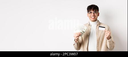 Happy person stands with money and plastic credit card. Young man ...