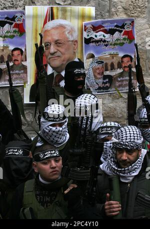Fatah militants carry their weapons in an alleyway in Rafah, southern ...