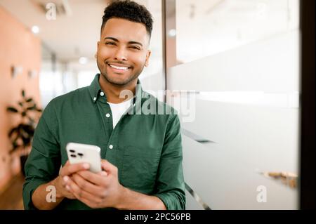 Handsome Latino businessman texting on mobile phone by the Seine Stock ...