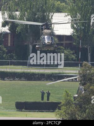 Two officers salute as the helicopter carrying the coffin of former ...