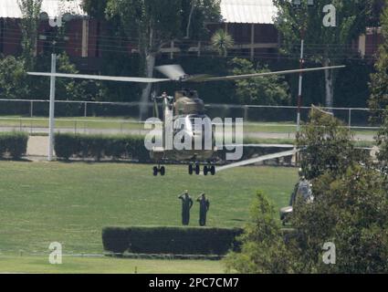 Two officers salute as the helicopter carrying the coffin of former ...
