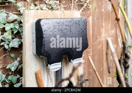 Waterproof electrical sockets installed outdoors on dark wooden walls ...