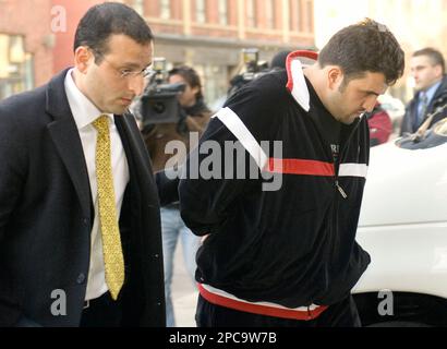 An unidentified suspect is escorted into the Royal Canadian Mounted ...