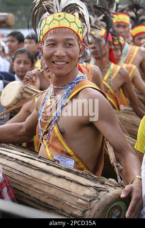 An Indian Garo tribal in traditional attire performs a traditional ...