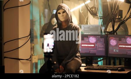 Female hacker with mask broadcasting live threat video, asking for ...