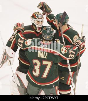 Minnesota Wild's Wes Walz, right, takes a hit from Edmonton Oilers ...