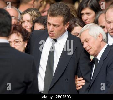 Leo Campione, center, stands with his parents as he watches the caskets ...
