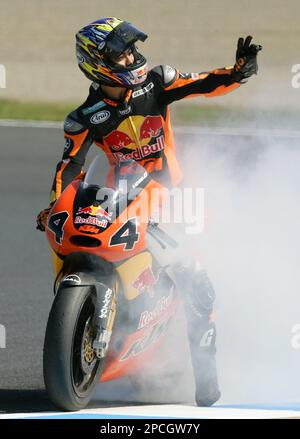 Japan's 250cc rider Hiroshi Aoyama holds hands aloft in celebration ...