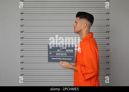 Prisoner with mugshot letter board at police department Stock Photo - Alamy