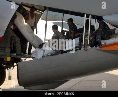 Indian Army personnel load supplies of blankets and tents into a ...
