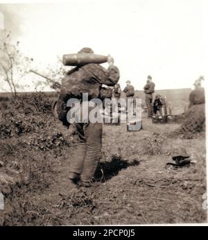 A soldier of the German Wehrmacht carries a shell for a Nebelwerfer ...