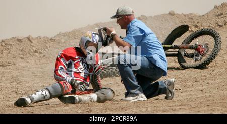 Motorcycle daredevil Trigger Gumm is helped to an ambulance by ...