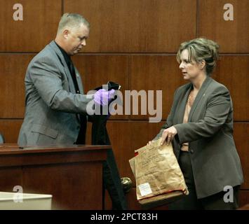 State attorney Leah Case, right, shows photographs of the body of Erin ...