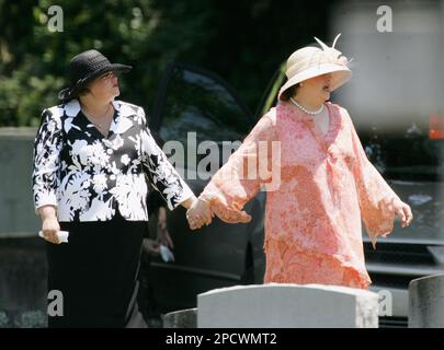Pam Paugh, left, sister of Patsy Ramsey, assists another attendee ...