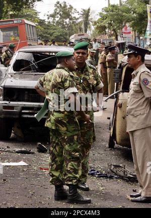 Sri Lankan army officers investigate the wreckage of a car, unseen, in ...