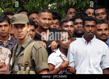 Sri Lankan army officers investigate the wreckage of a car, unseen, in ...