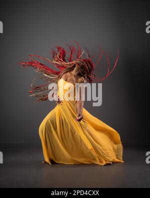 African american woman wearing yellow sweater at kitchen making fish ...