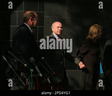 Enron founder Ken Lay and his wife Linda walk across a street in ...