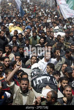 Palestinians carry fourteen bodies during the funeral procession for ...
