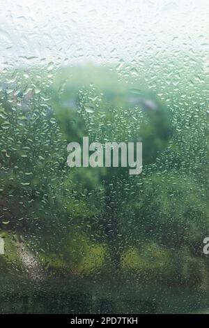 Raindrops on glass during rain, large drops. Landscape with raindrops ...