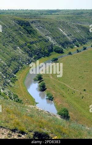 Beautiful natural gorge strewn with hills, grass and trees. At bottom ...