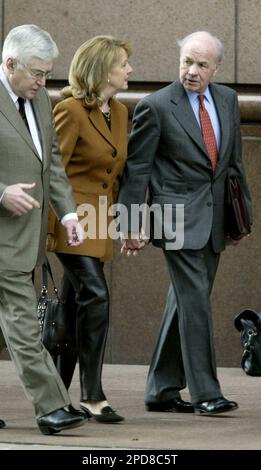 Enron founder Ken Lay and his wife Linda walk across a street in ...