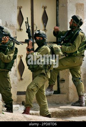 Israeli soldiers take up position during an Israeli military operation ...