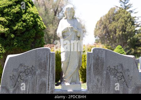 Stone statue of Jesus Christ pointing at His Sacred Heart on a ...