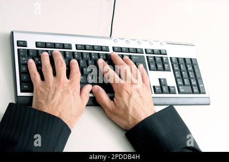 Mens fingers typing on the keyboard, which is composed of salty cracker ...
