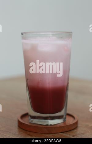 a glass of red velvet latte served cold on the table Stock Photo - Alamy
