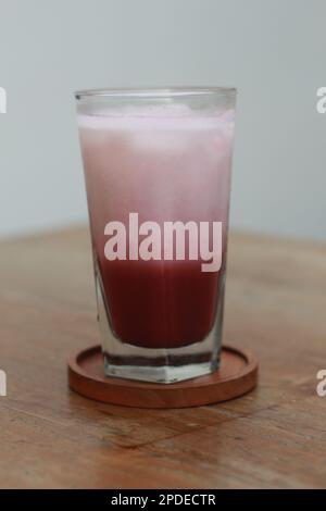 a glass of red velvet latte served cold on the table Stock Photo - Alamy