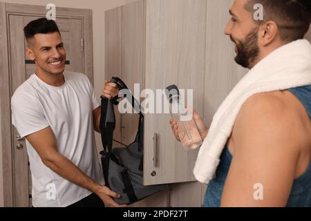 Handsome men changing clothes in locker room Stock Photo - Alamy