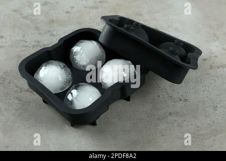 Frozen ice balls in mold on grey table Stock Photo - Alamy